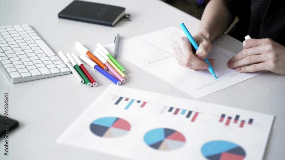 Woman fills data in graphs on paper. Records information. Woman is ...