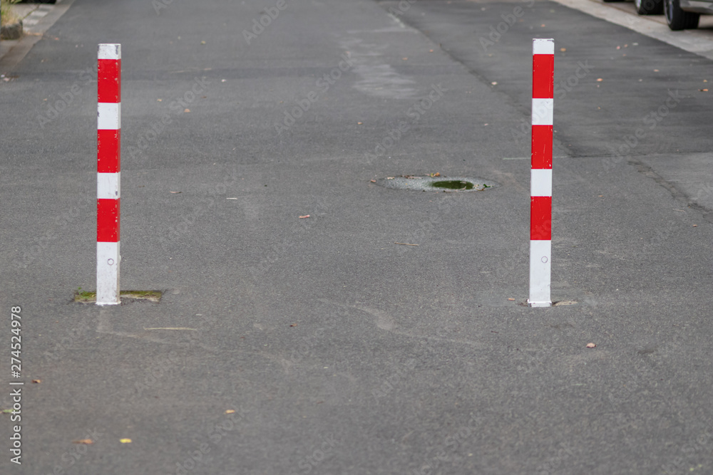 Rot weiß gestreifte Pfeiler hindern Autos an der Durchfahrt einer ...