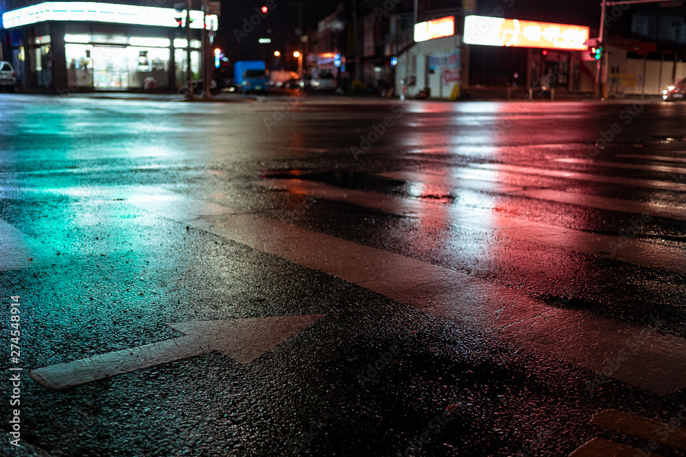 Foto de Crosswalk with pointing arrow in the night in neon light. wet ...