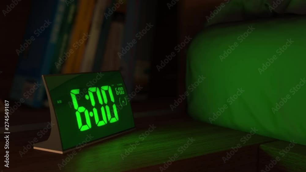 Digital alarm clock in a bedroom waking up at 6 AM. Close-up view. The ...