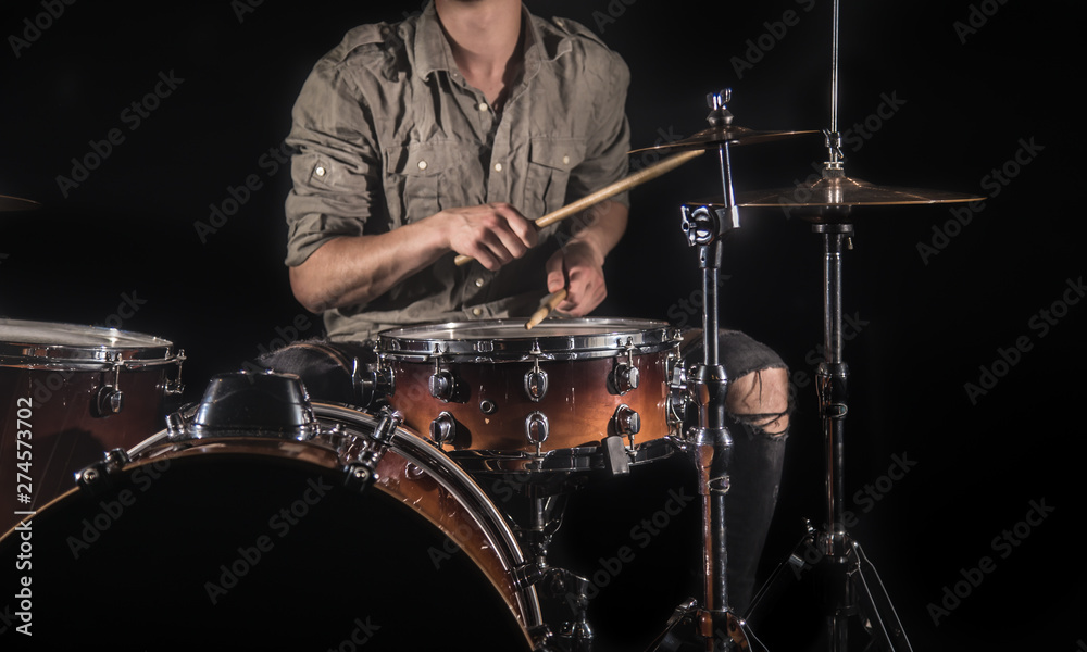 Professional drummer playing on drum set on stage on the black ...