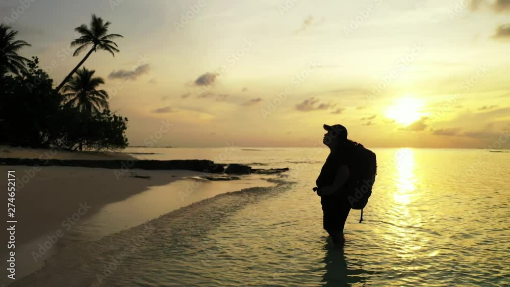 dolly in ful shot of tourist admiring golden colors of the beach on ...