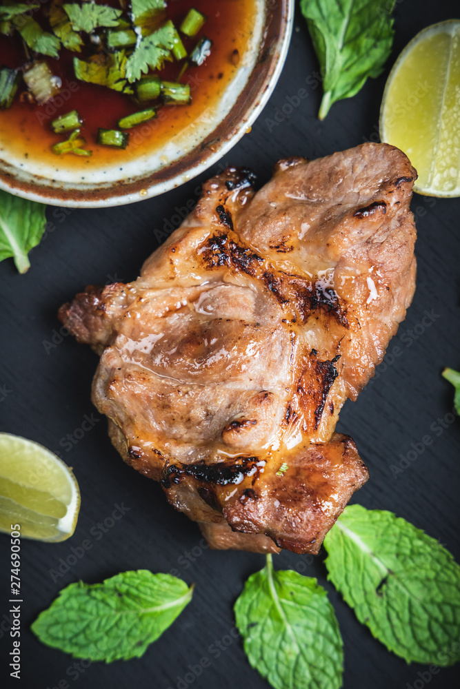 Top view grilled beef steak on a black background with herbs and spices ...