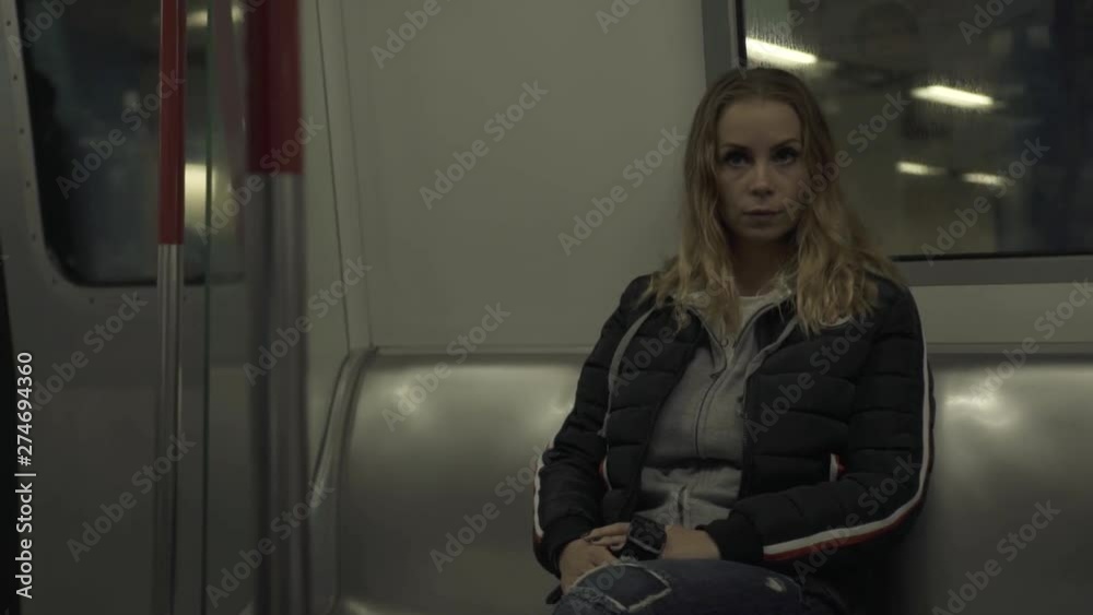 Young woman riding in subway train. Traveler woman sitting on seat ...