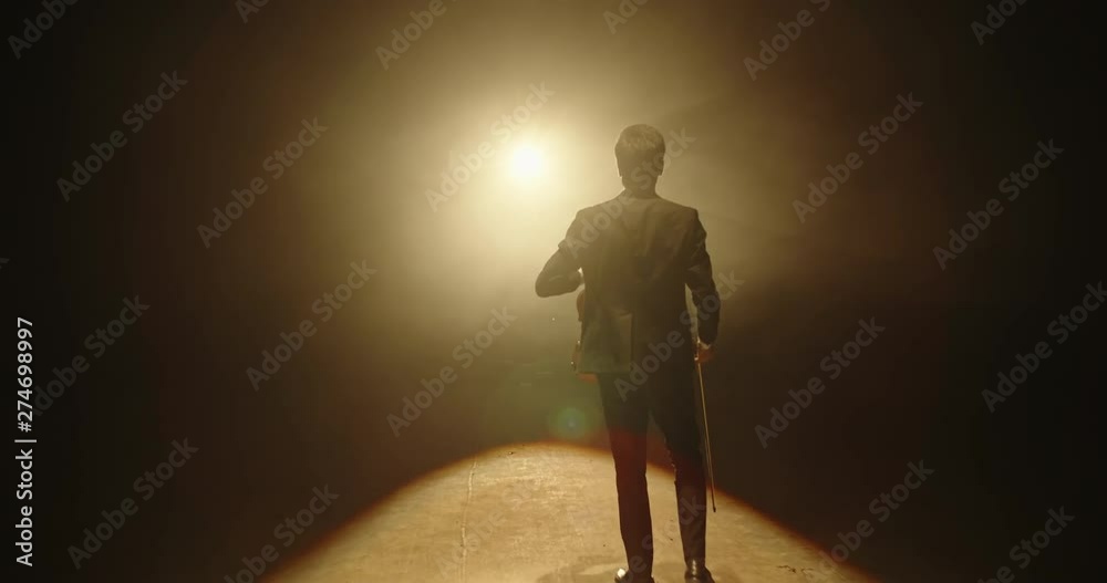 Professional violin player making steps on stage before performing a ...
