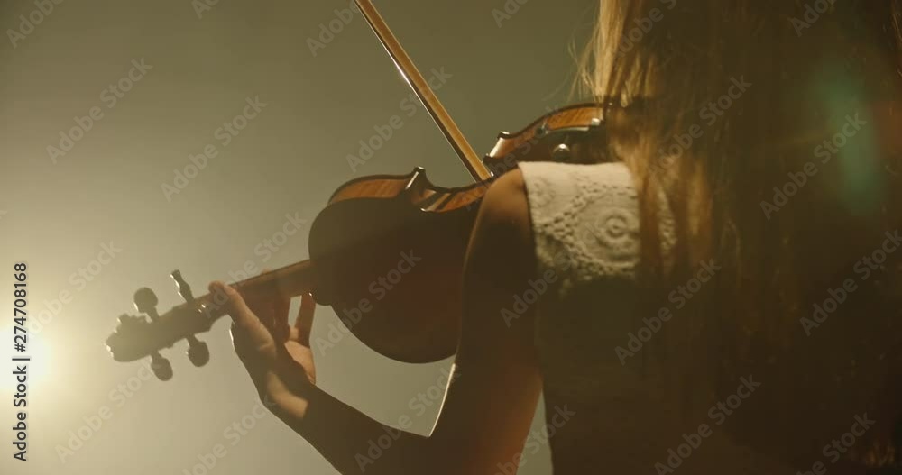 Experienced asian female violin player having a solo during the concert ...