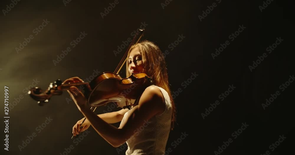 Professional female violinist performing a solo concert on stage ...