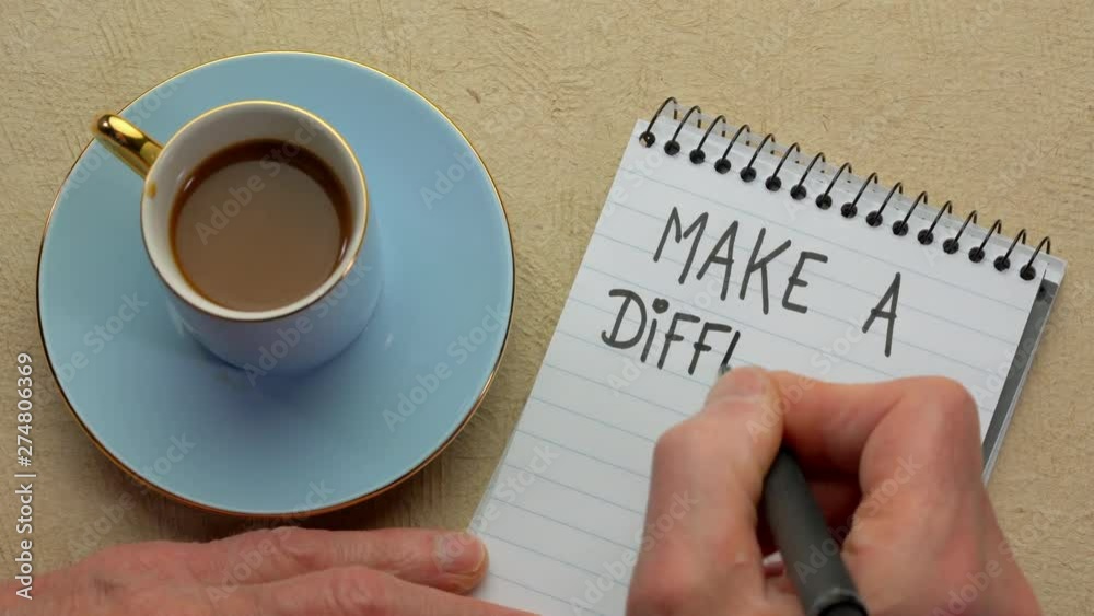 Make a difference - man hand writing a note with a black marker in a ...