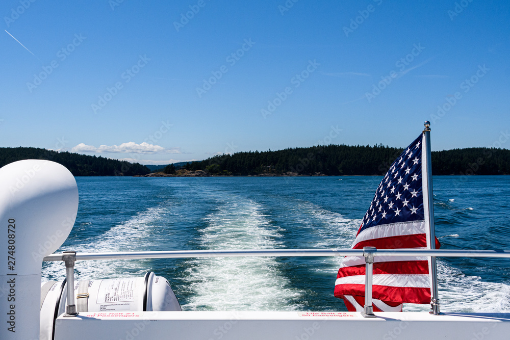 Symbol of freedom, American flag flying on the back of a boat cruising ...