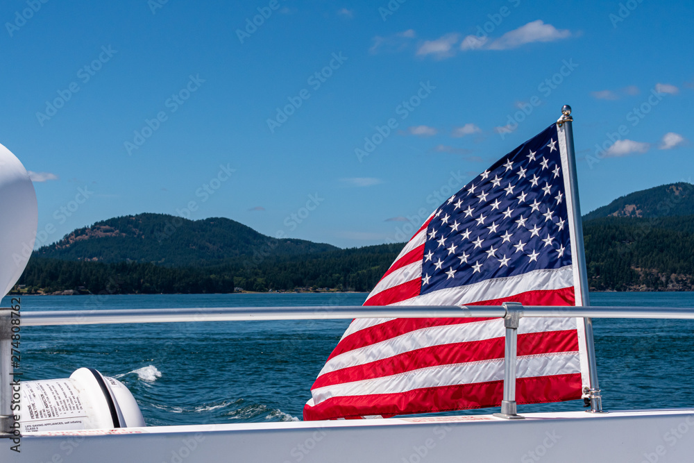 Symbol of freedom, American flag flying on the back of a boat cruising ...