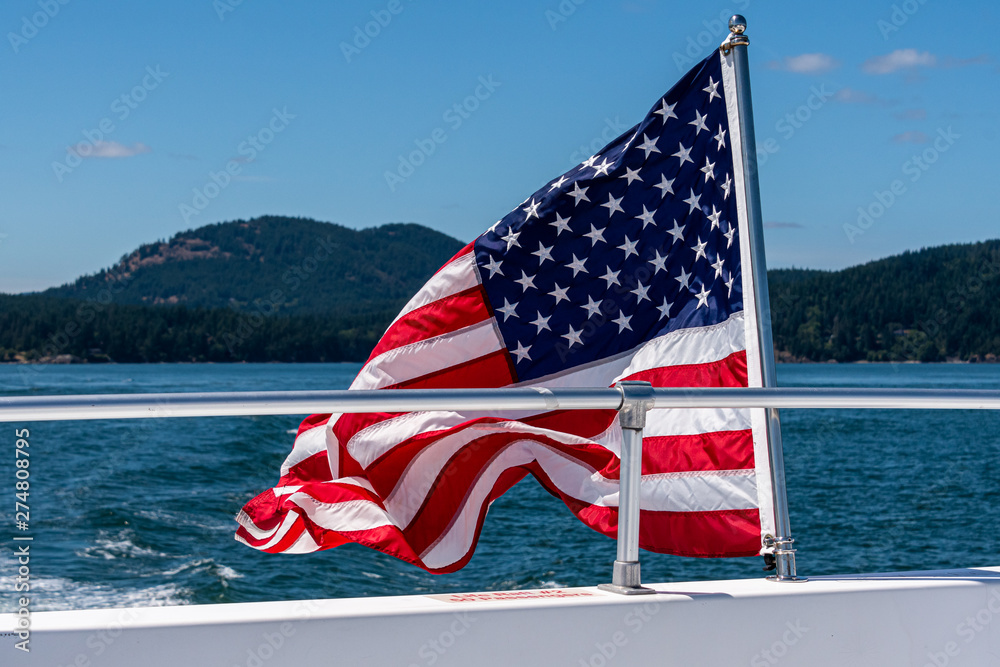 Symbol of freedom, American flag flying on the back of a boat cruising ...