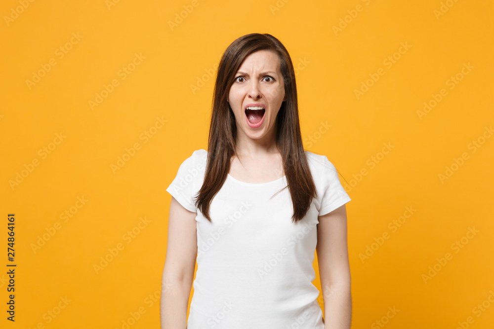 Portrait of shocked disgusted screaming young woman in white casual ...