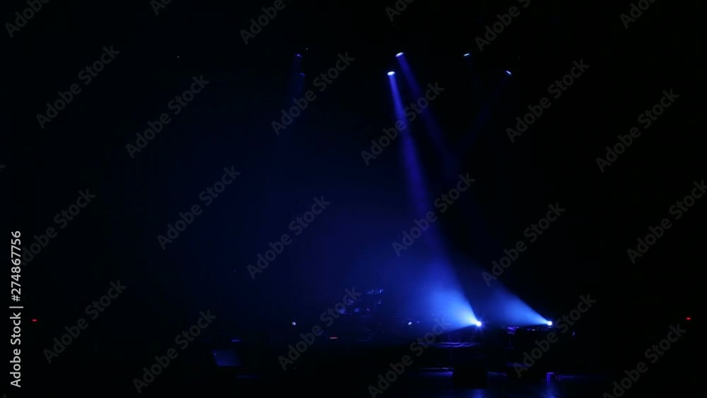 Blue spotlight on an empty concert stage in the dark. Free stage with ...