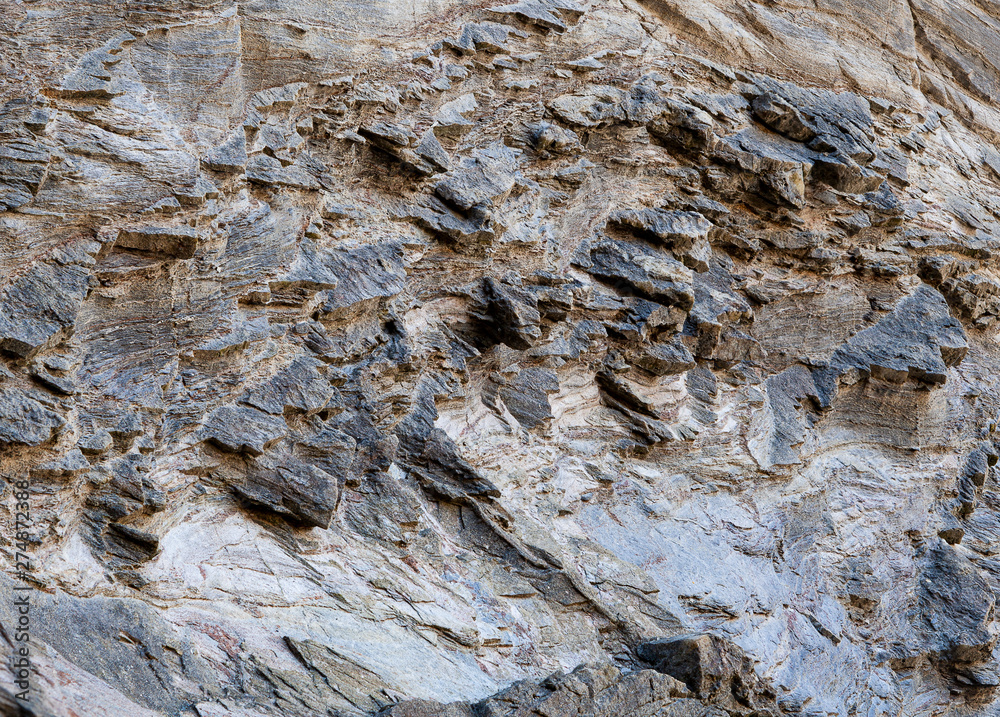 Surface of rocky wall with different hardnesses where the parts of the ...