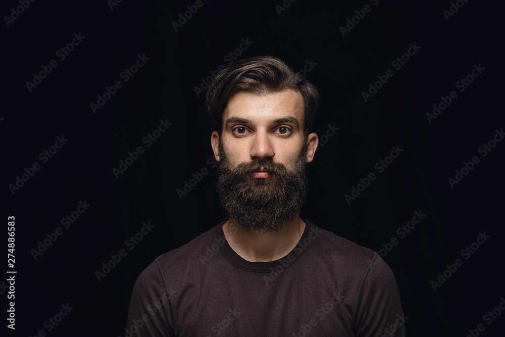Close up portrait of young caucasian man isolated on black studio ...