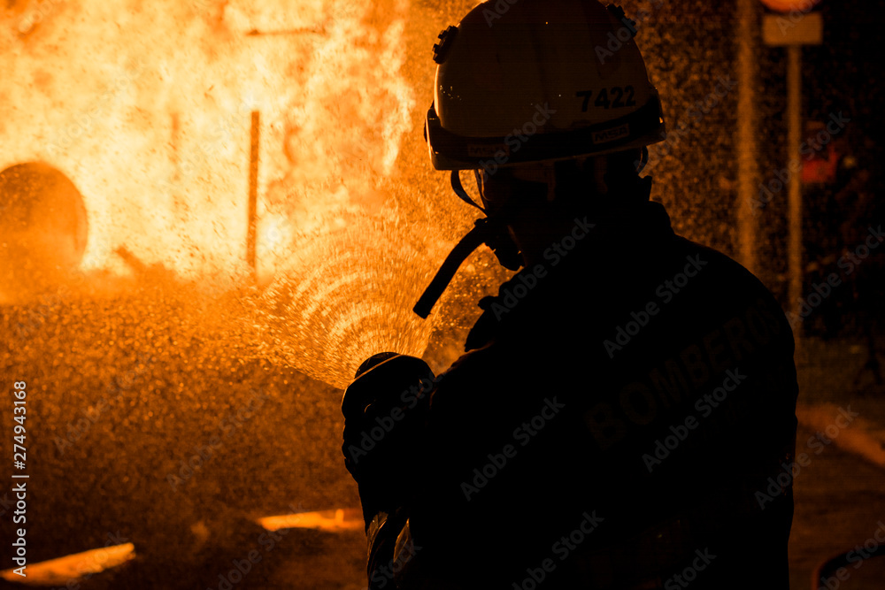 bombero apagando fuego con manguera Stock Photo | Adobe Stock