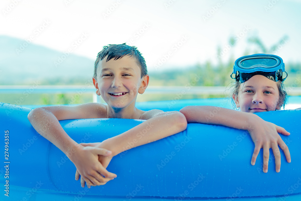 Little girl and boy in swimming pool on sunny day Stock Photo | Adobe Stock