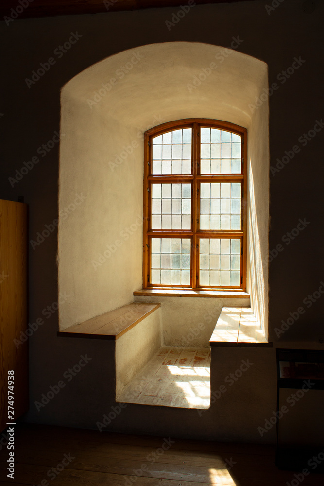 An arched window opening in an old castle and benches made by the ...