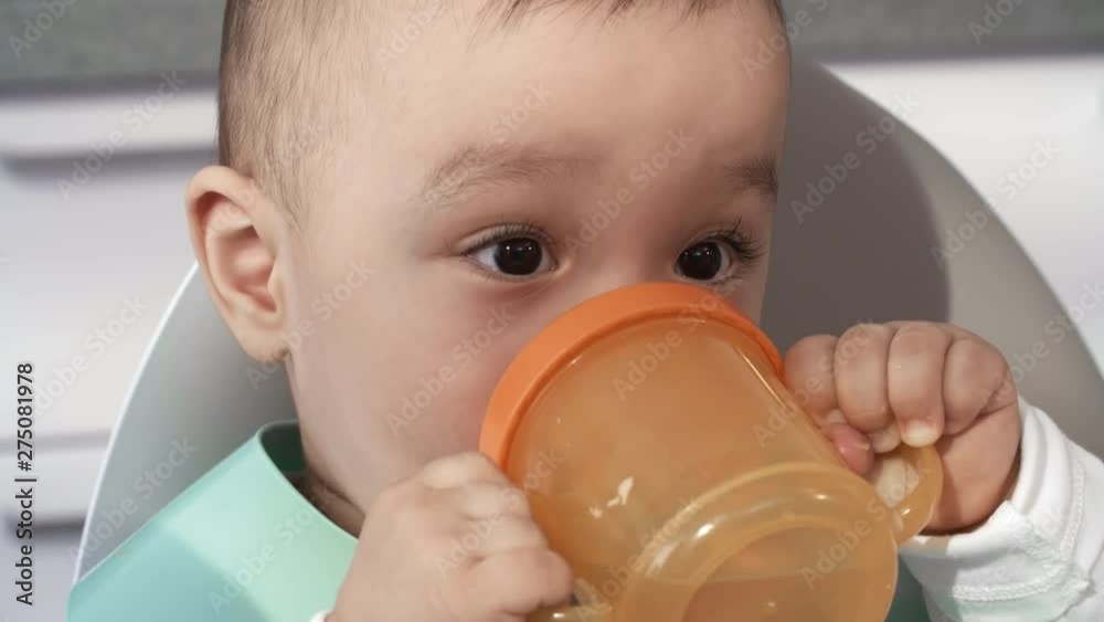Close-up face shot of sloppy 1-year-old Asian baby with beautiful dark ...