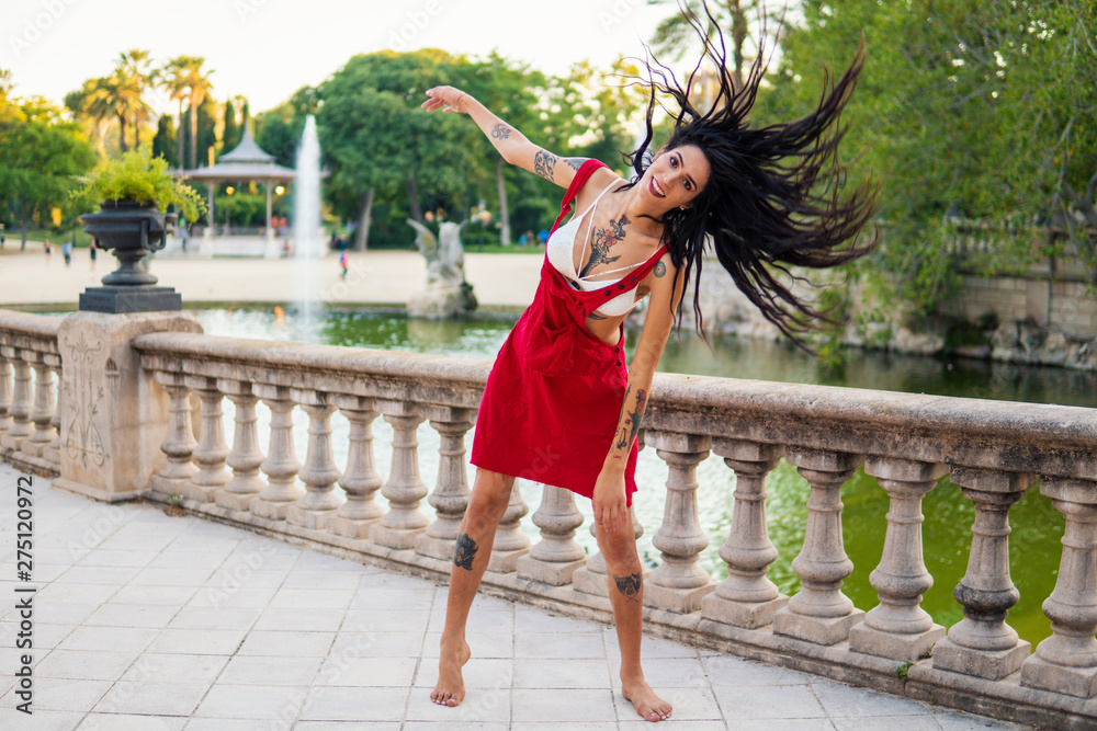 tattooed transgender model is dancing in the green park. Emotional ...