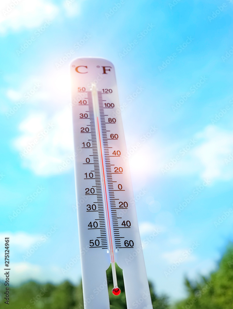 thermometer against sunny sky background. high temperature on sunlight ...