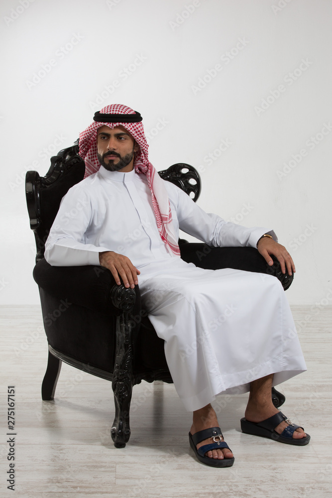 Portrait of an arab man sitting down on a chair. Stock Photo | Adobe Stock