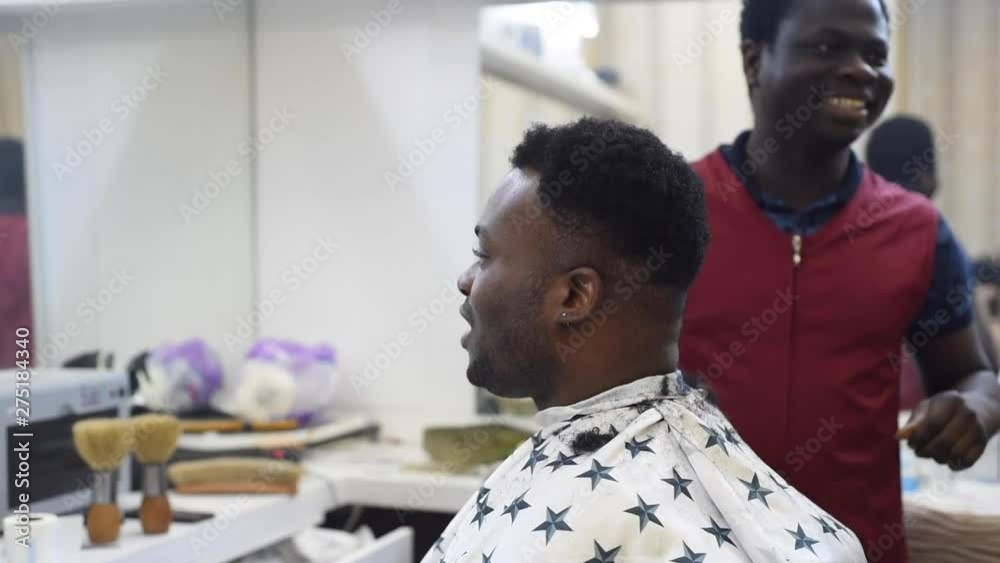 Black man in the african barbershop. Cute black man makes a haircut in ...