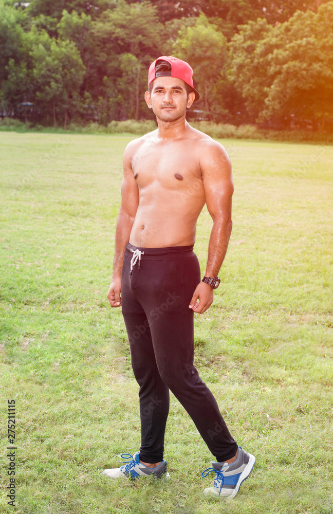 Fitness model man with a beautiful healthy body with muscles posing in ...