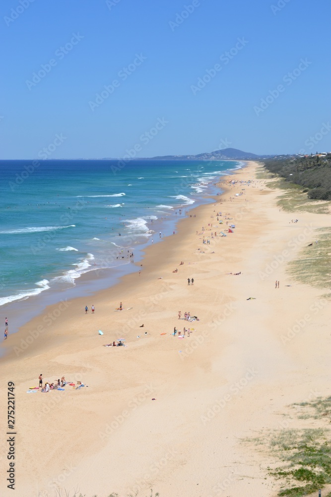 Long stretch of sandy white beach to vanishing point with blue ocean ...