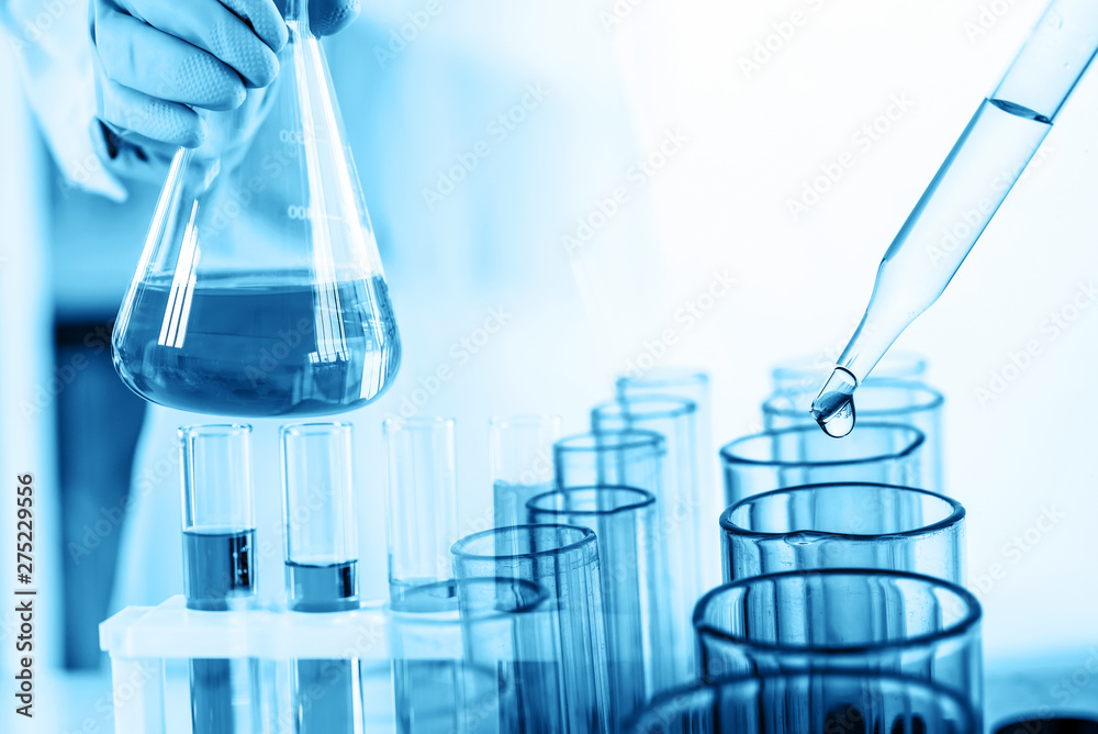 hand of scientist holding flask with lab glassware and test tubes in ...