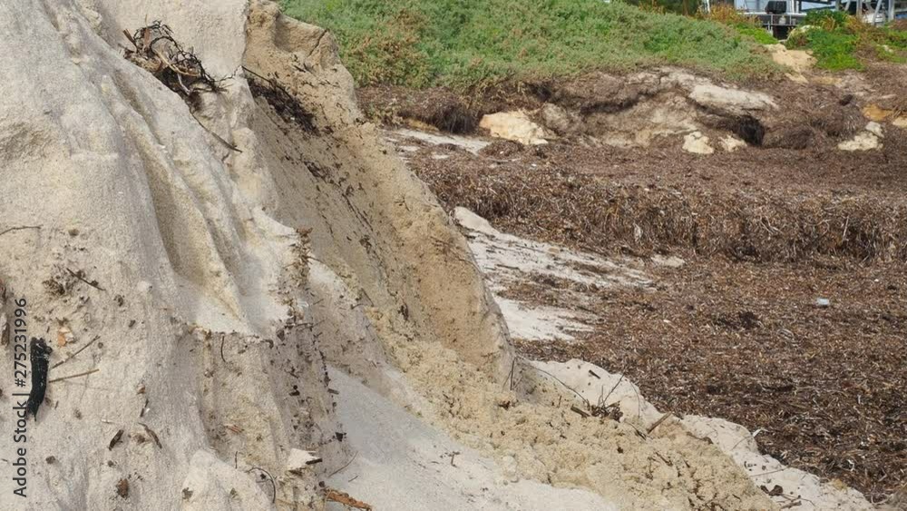 Eroded beach sand bank collapses as man in jeans steps down. 60fps copy ...