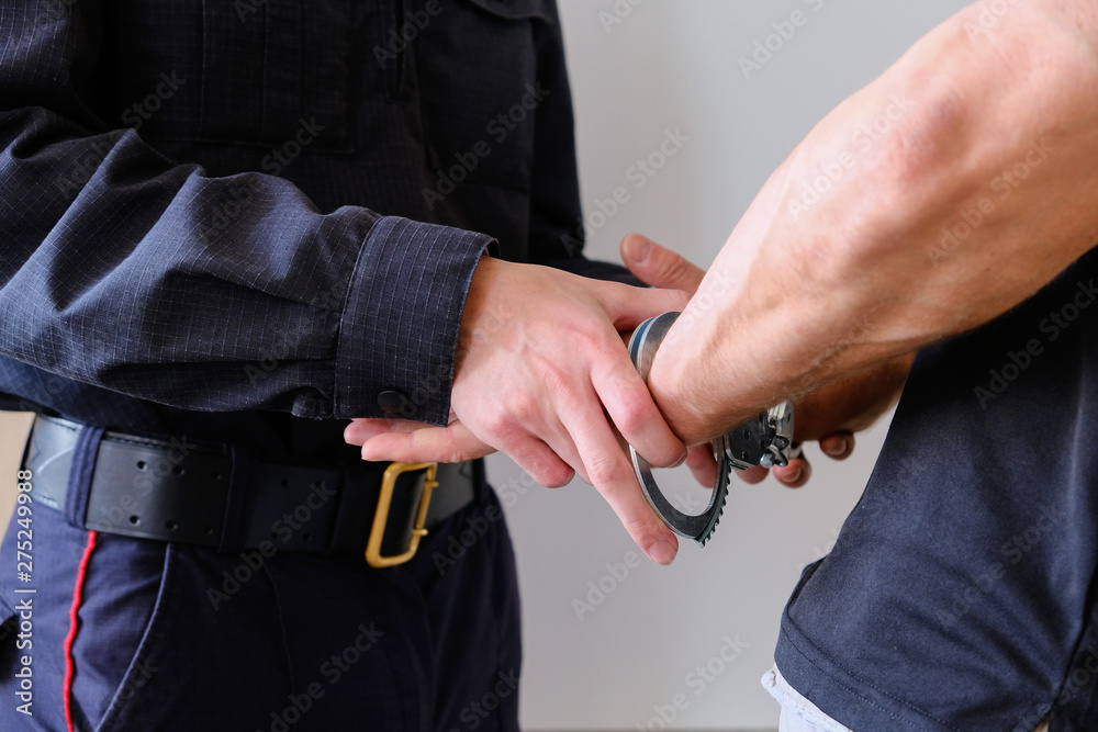 Buttons COP handcuffs an arrested criminal. The man at the police ...