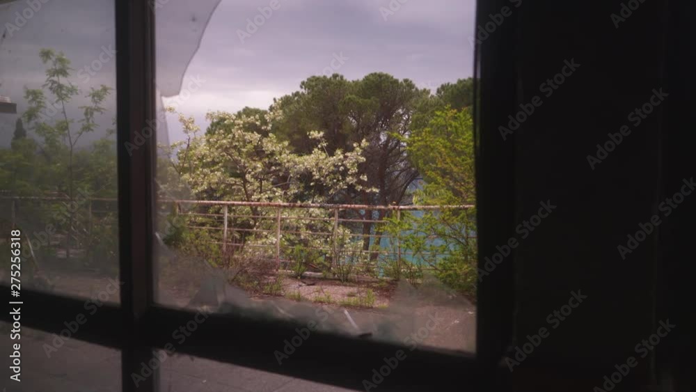 Haunting and mysterious, first person looking through shattered window ...