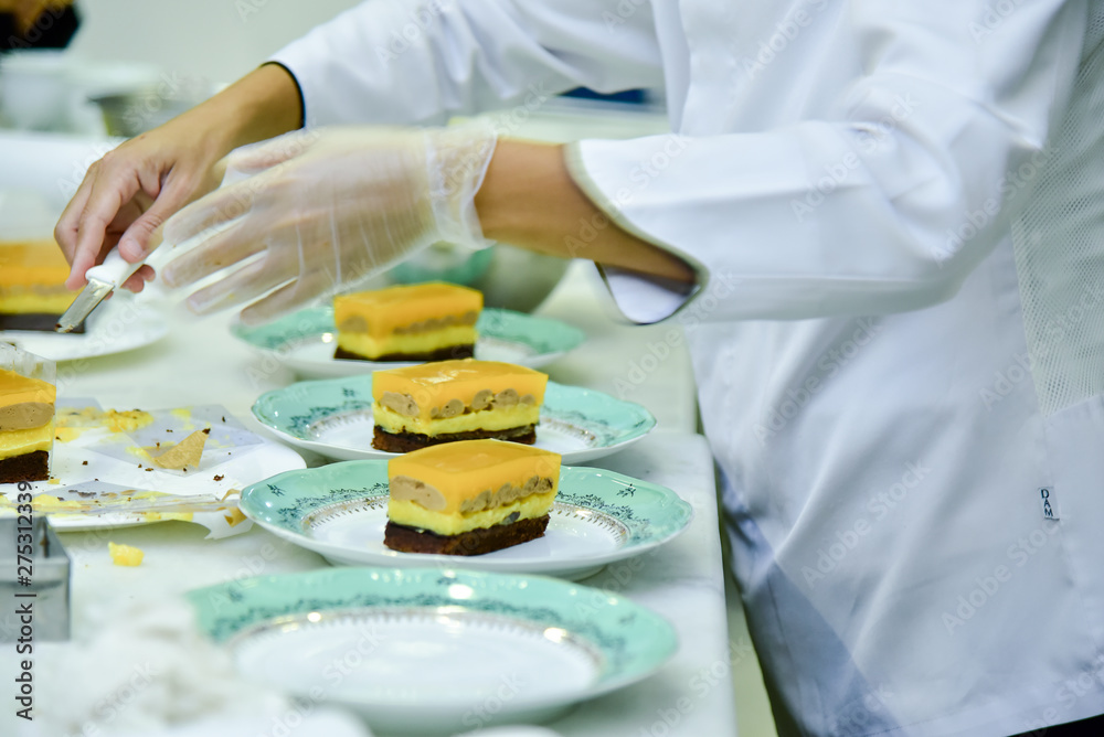 chef in industrial kitchen serving passion fruit pies with chocolate ...