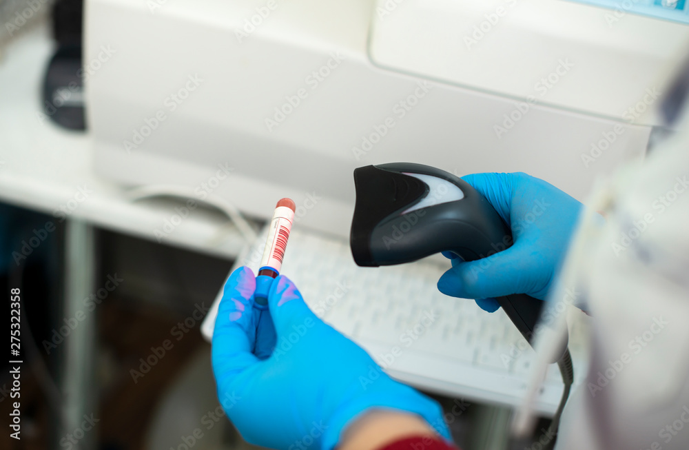 Bar code scanner and test tube over monitor of complete blood count ...
