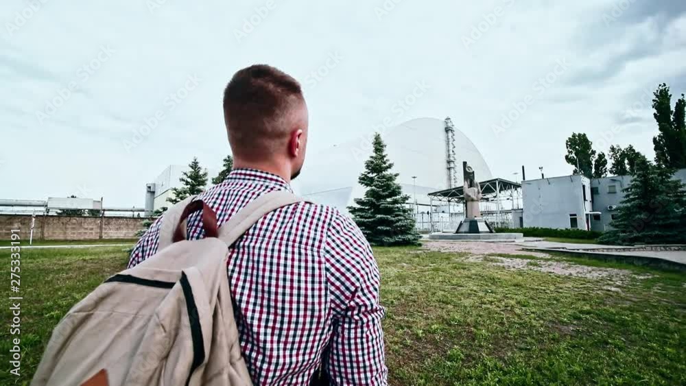 Chernobyl Power Plant today. Back view of amazed young man overlooking ...