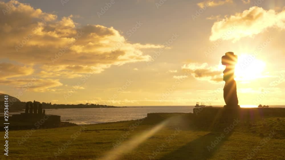 LENS FLARE, SILHOUETTE: Golden evening sunbeams shine on the moai ...