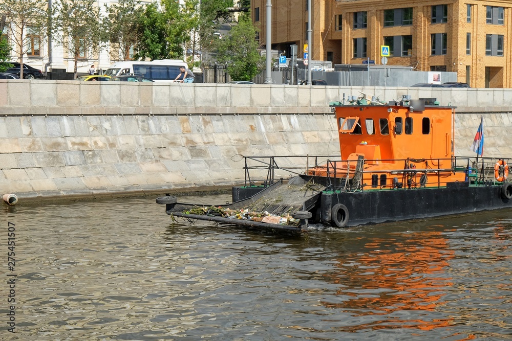 River cleaning boat collects garbage on water surface of river.Trash ...