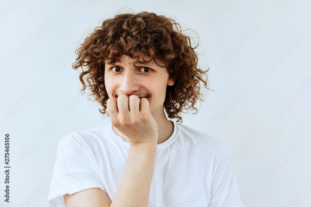 Fear,Shame and shy emotion. Portrait of Curly teen guy against white ...