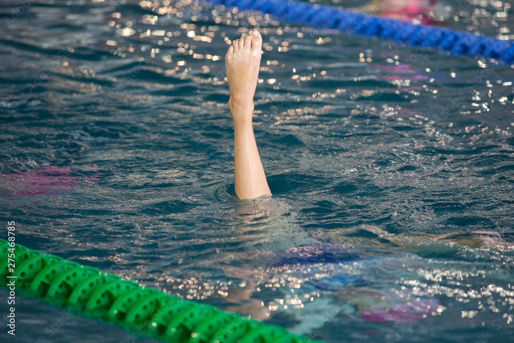 Synchronized Swimmers point up out of the water in action. Synchronized ...