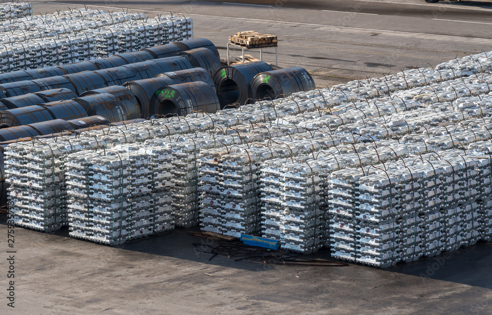 Ingots of aluminum and rolls of steel line the quayside in the Port of ...