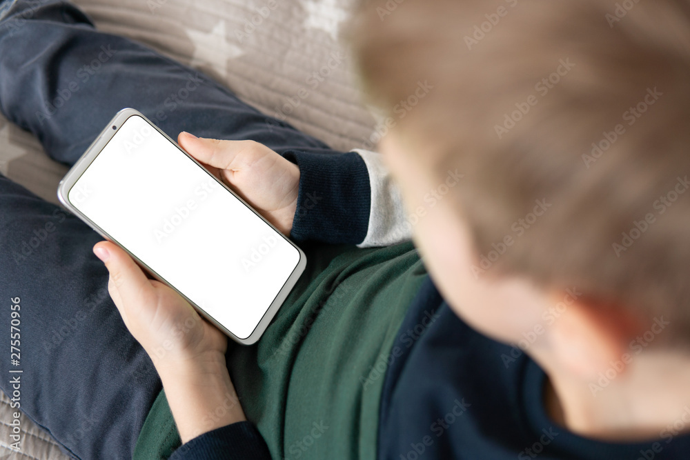 Smartphone with a mock up in the hands of a child. close up top view ...