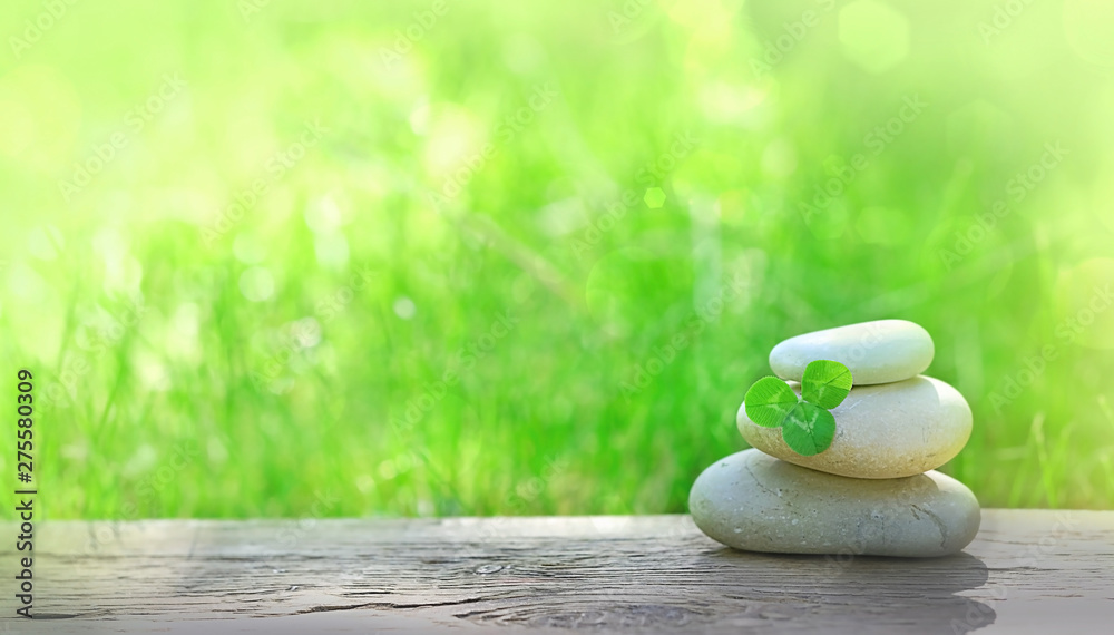 Stack of zen stones and Shamrock clover leaf on abstract nature ...