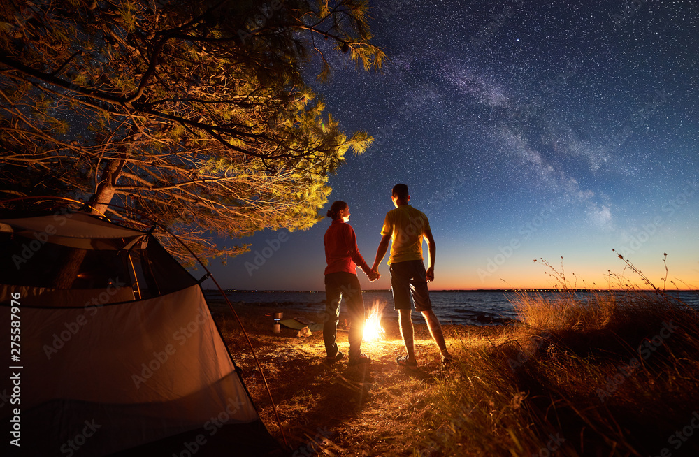 Night camping at sea under blue starry sky with Milky way. Back view of ...