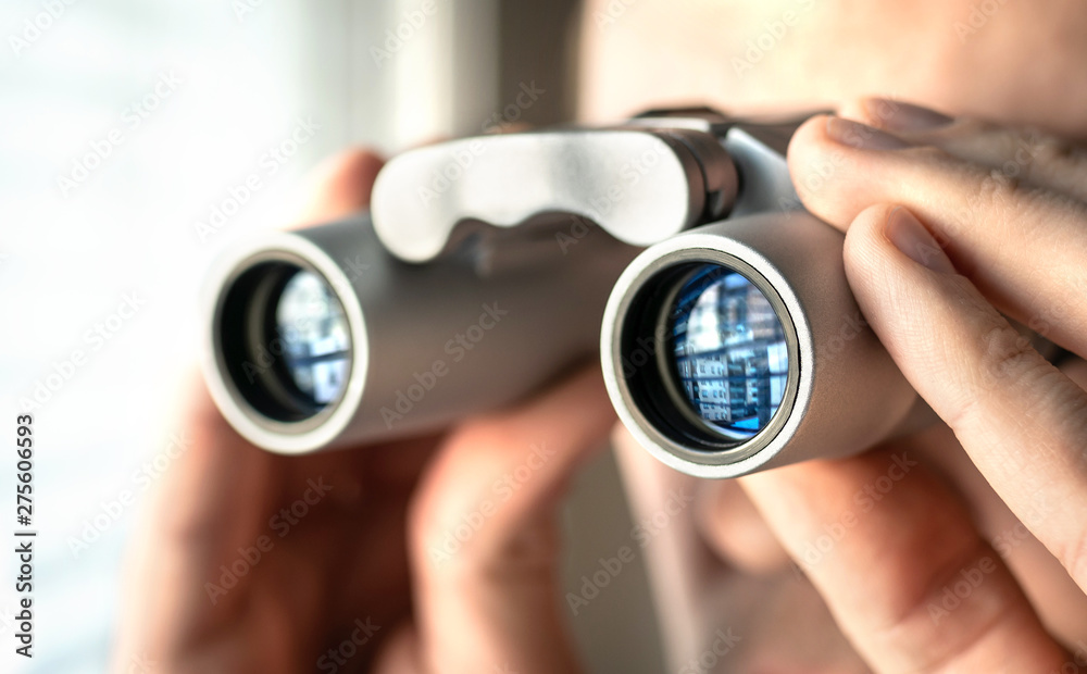 Man watching out the window with binoculars. Curious and nosy neighbour ...