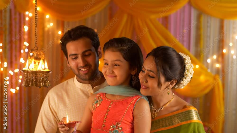 Nuclear Indian family portrait : Little daughter lighting diyas ...