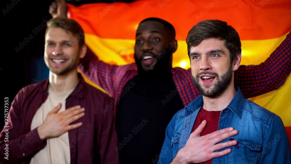 Spanish multiethnic male football fans singing national anthem and ...