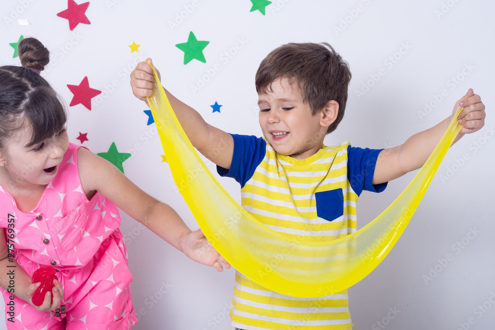 Kid playing hand made toy called slime. Children play with big yellow ...