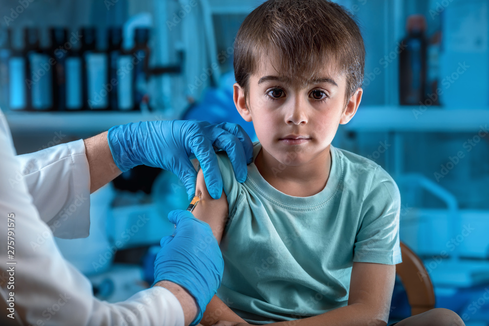 doctor injecting vaccine preventive to little boy in the hospital Stock ...