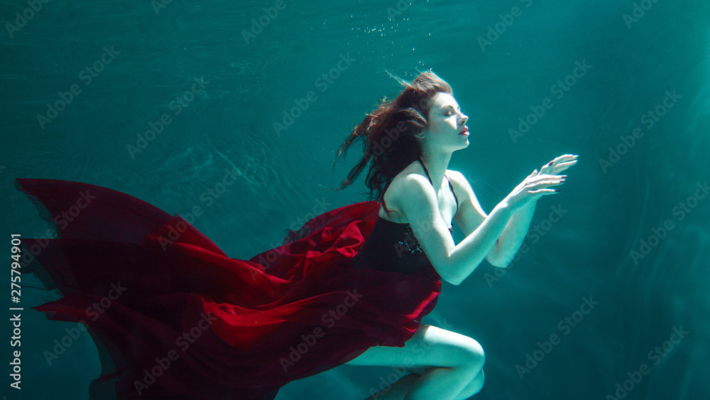 beautiful girl in a red dress swims under water Stock Photo | Adobe Stock